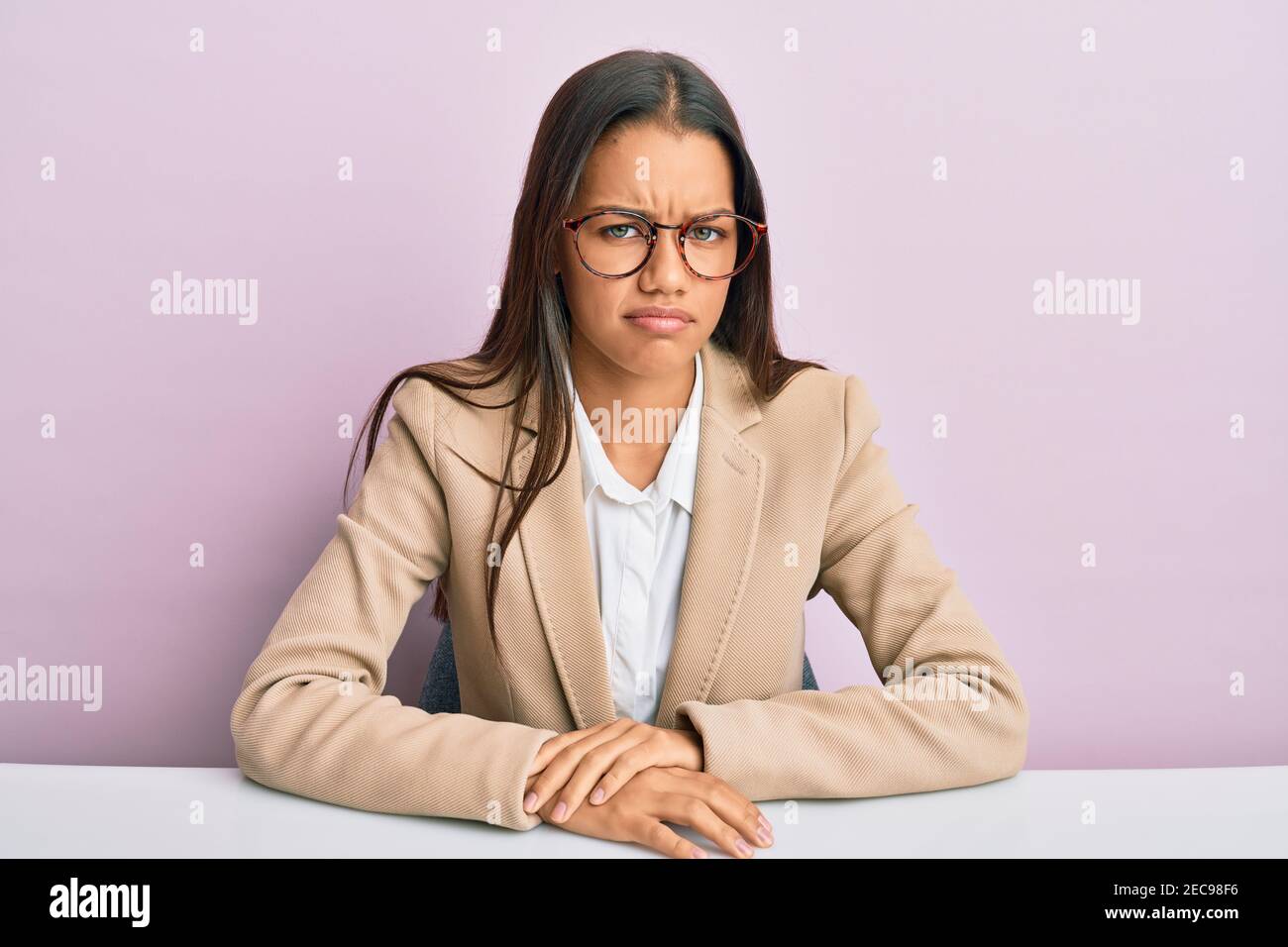 Beautiful hispanic woman working at the office skeptic and nervous ...