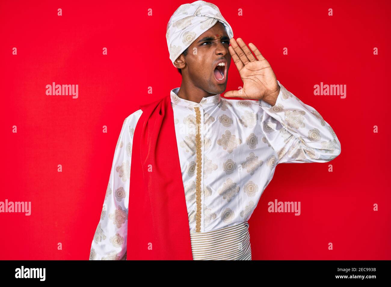 Handsome indian man wearing tradition sherwani saree clothes shouting ...