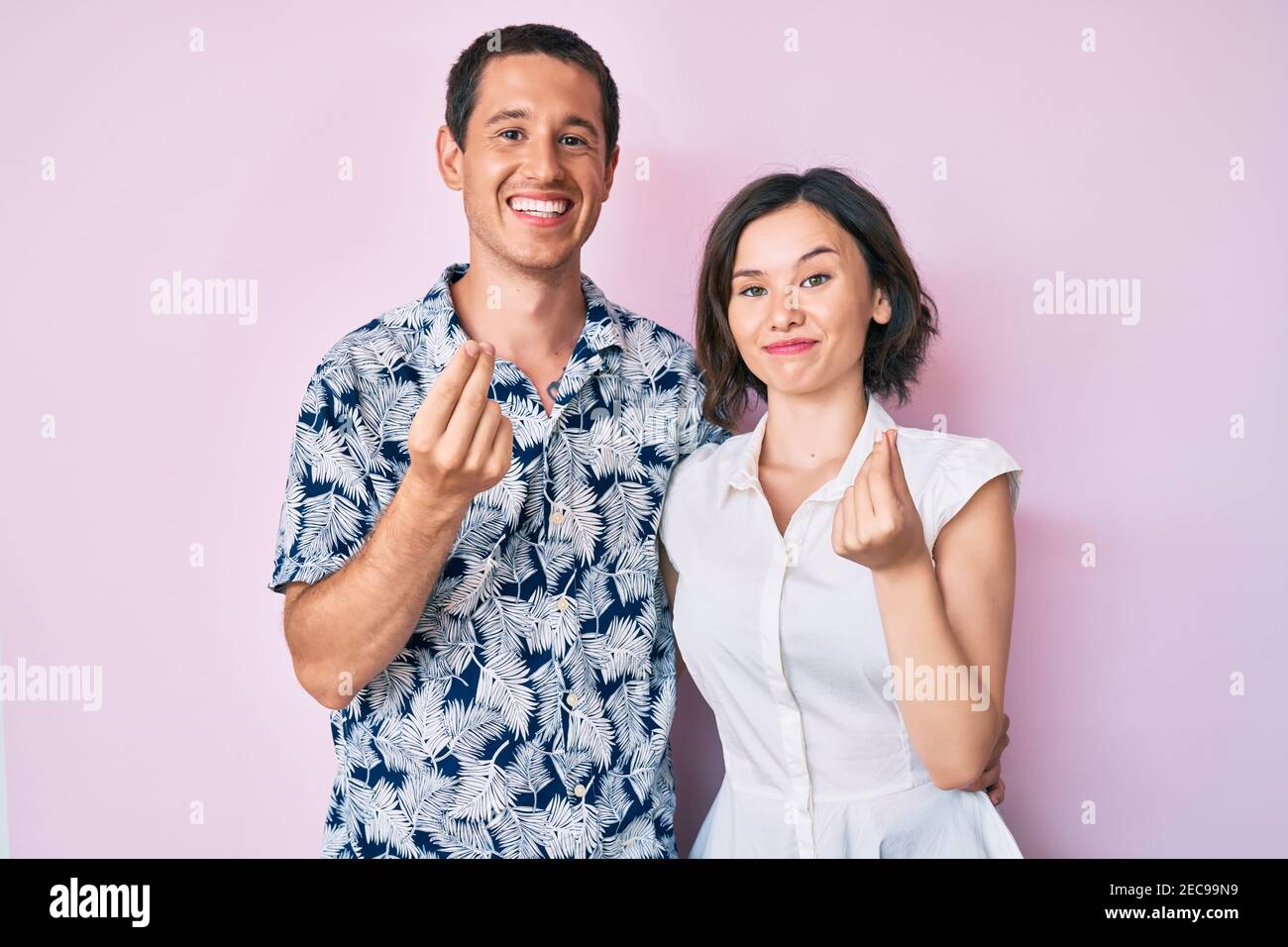Beautiful couple wearing casual clothes doing money gesture with hands ...