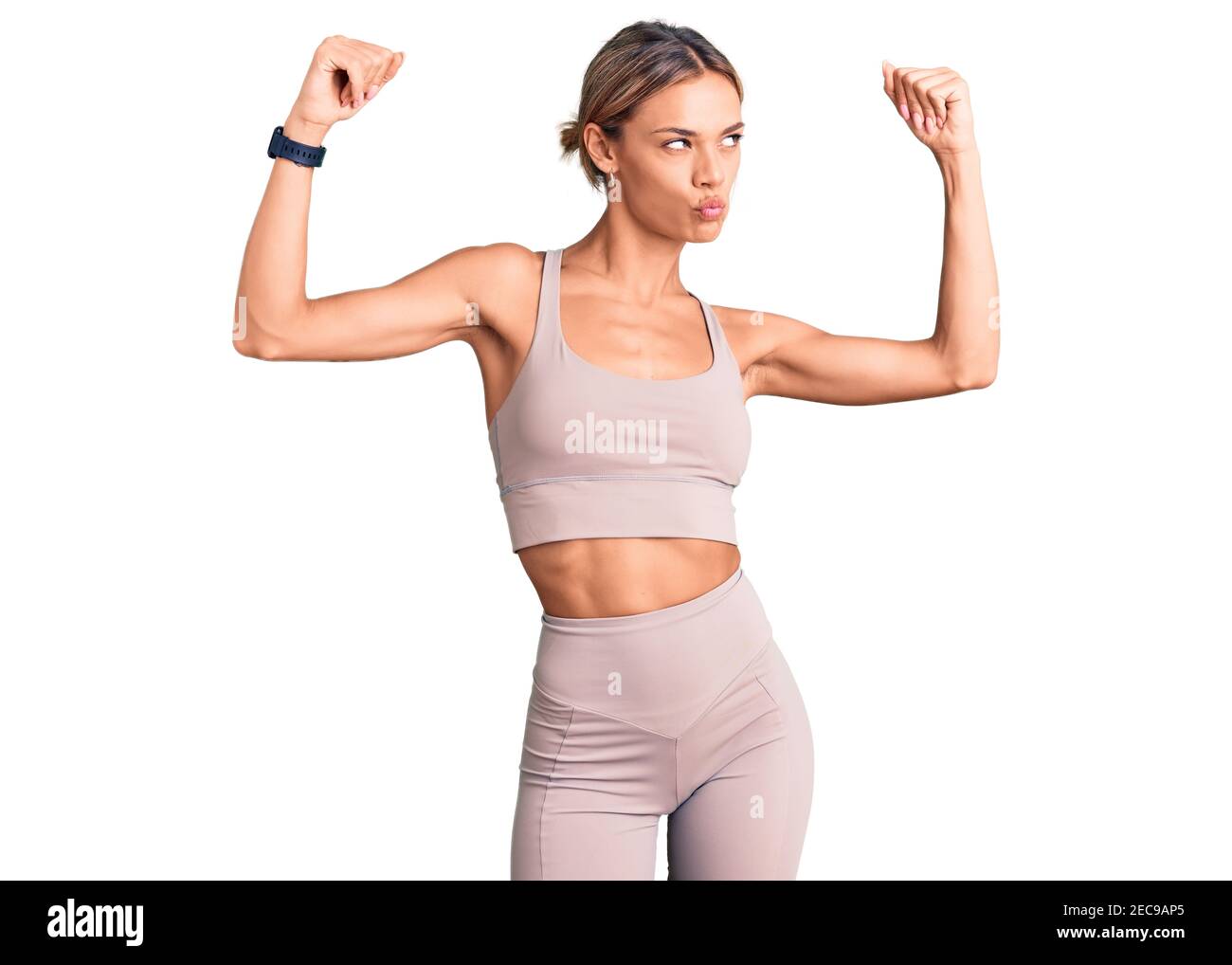 Beautiful caucasian woman wearing sportswear showing arms muscles ...