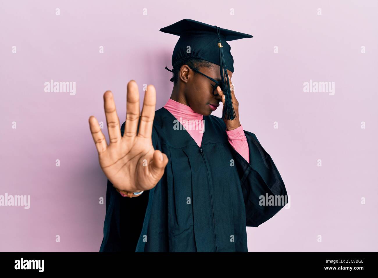 Young african american girl wearing graduation cap and ceremony robe ...