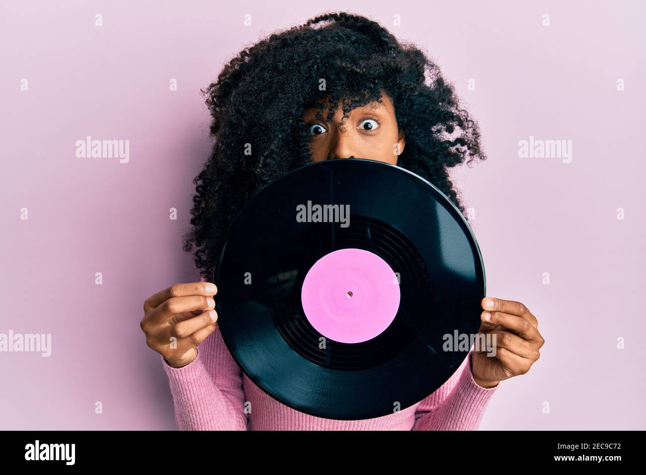 African american woman with afro hair holding vinyl disc celebrating ...