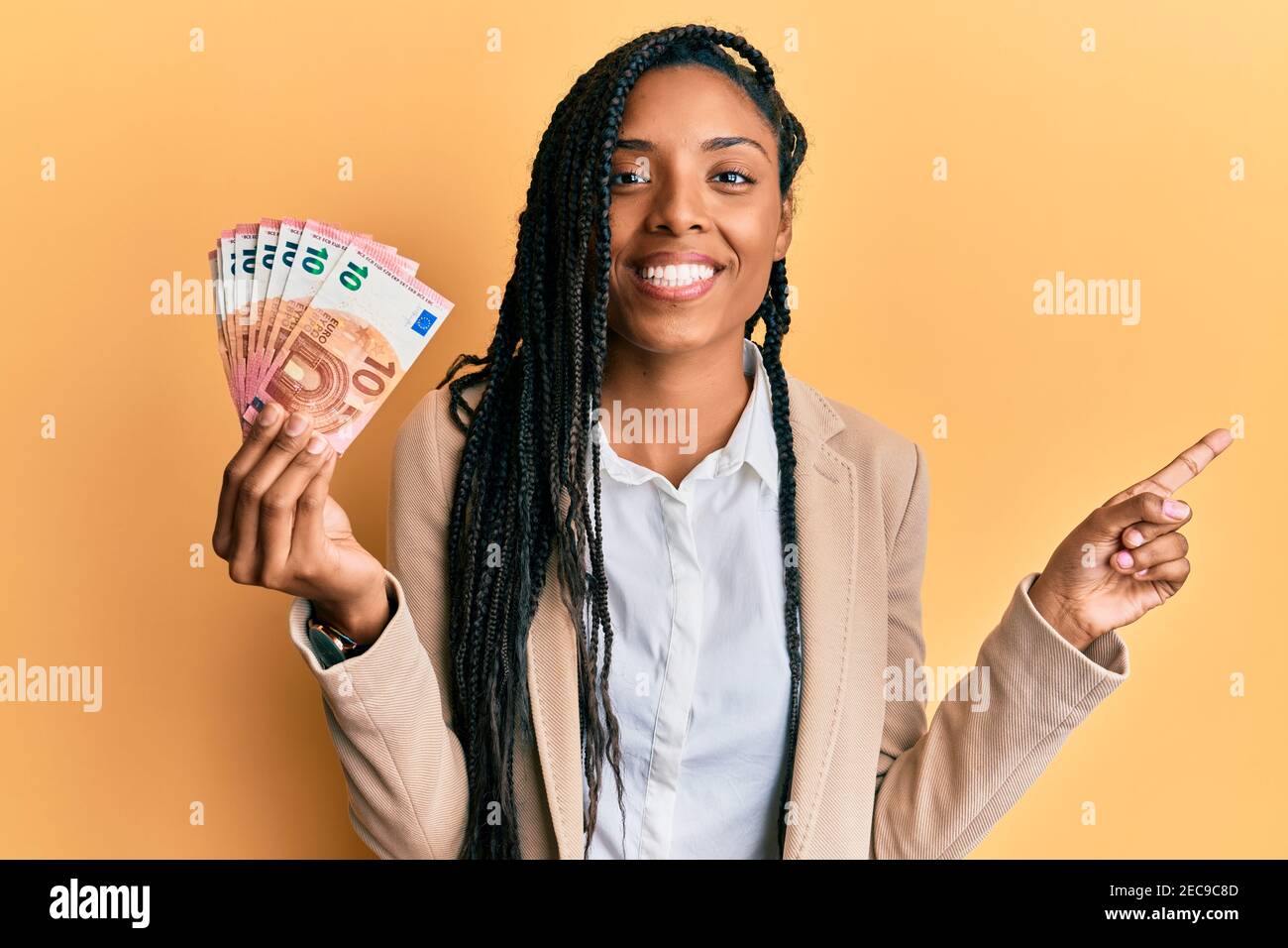 African american woman with braids holding bunch of 10 euro banknotes ...