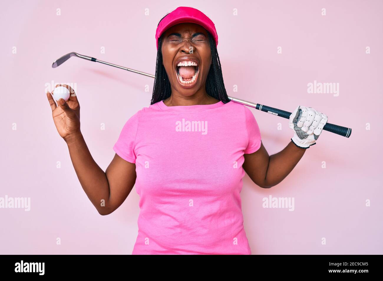 African american golfer woman with braids holding golf ball angry and ...