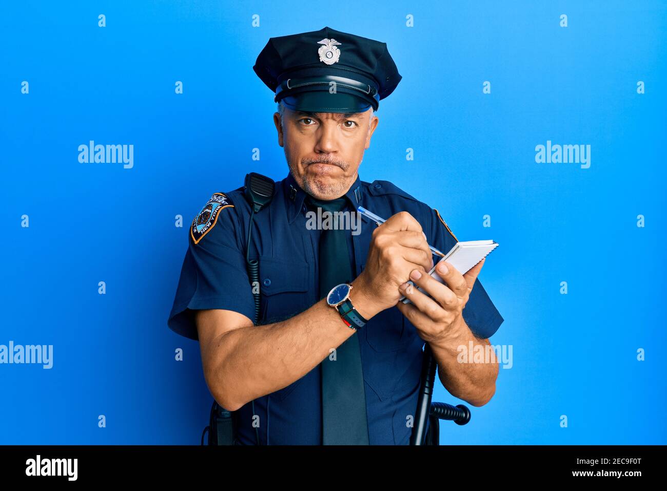 Handsome middle age mature man wearing police uniform writing a ticket ...