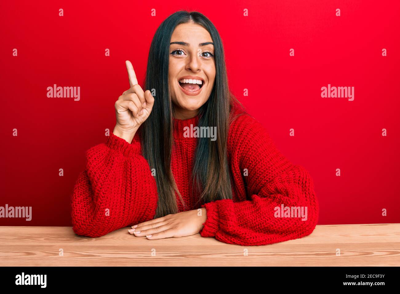 Beautiful Hispanic Woman Wearing Casual Clothes Sitting On The Table