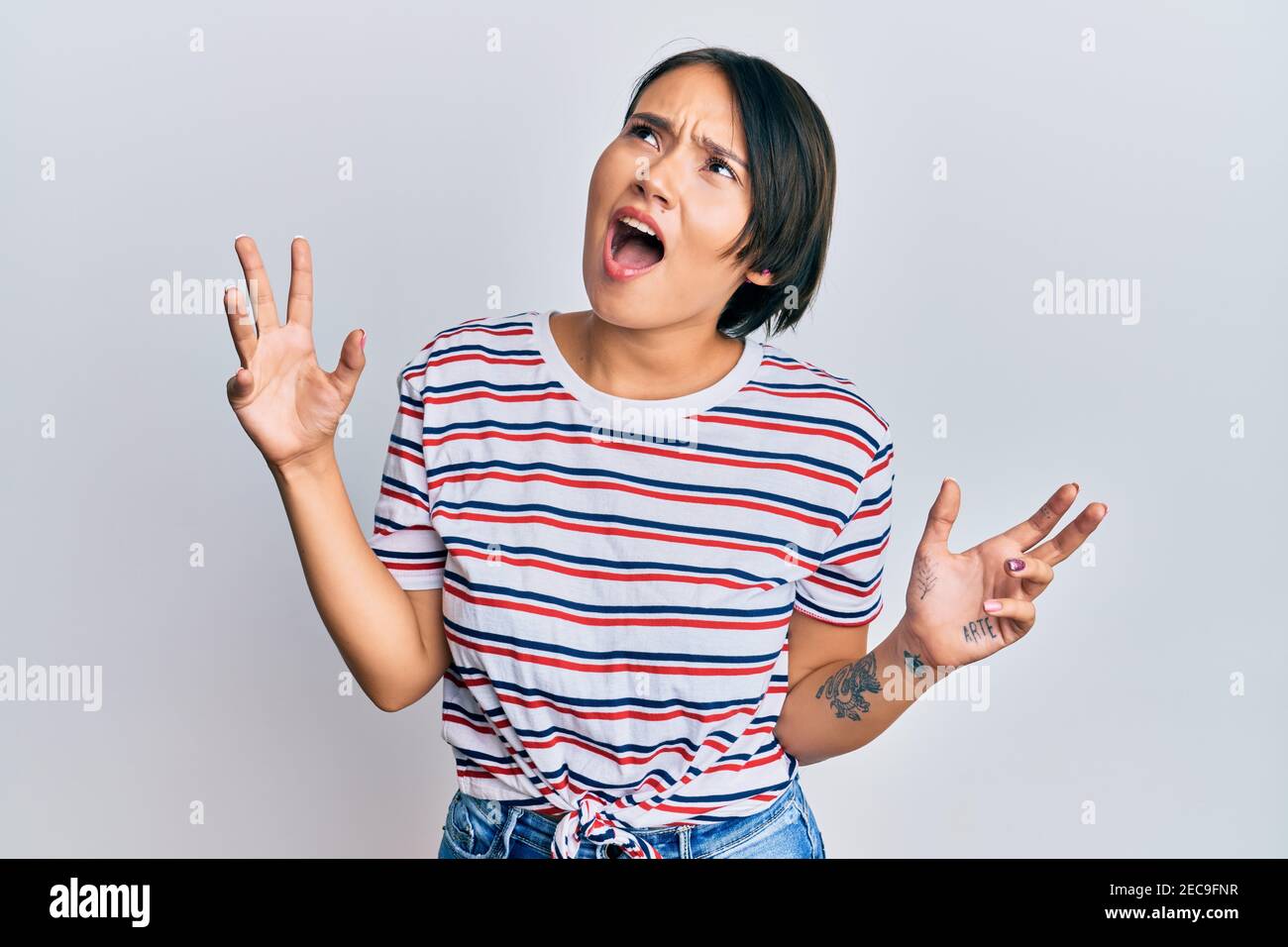 Beautiful young woman with short hair wearing casual clothes crazy and ...