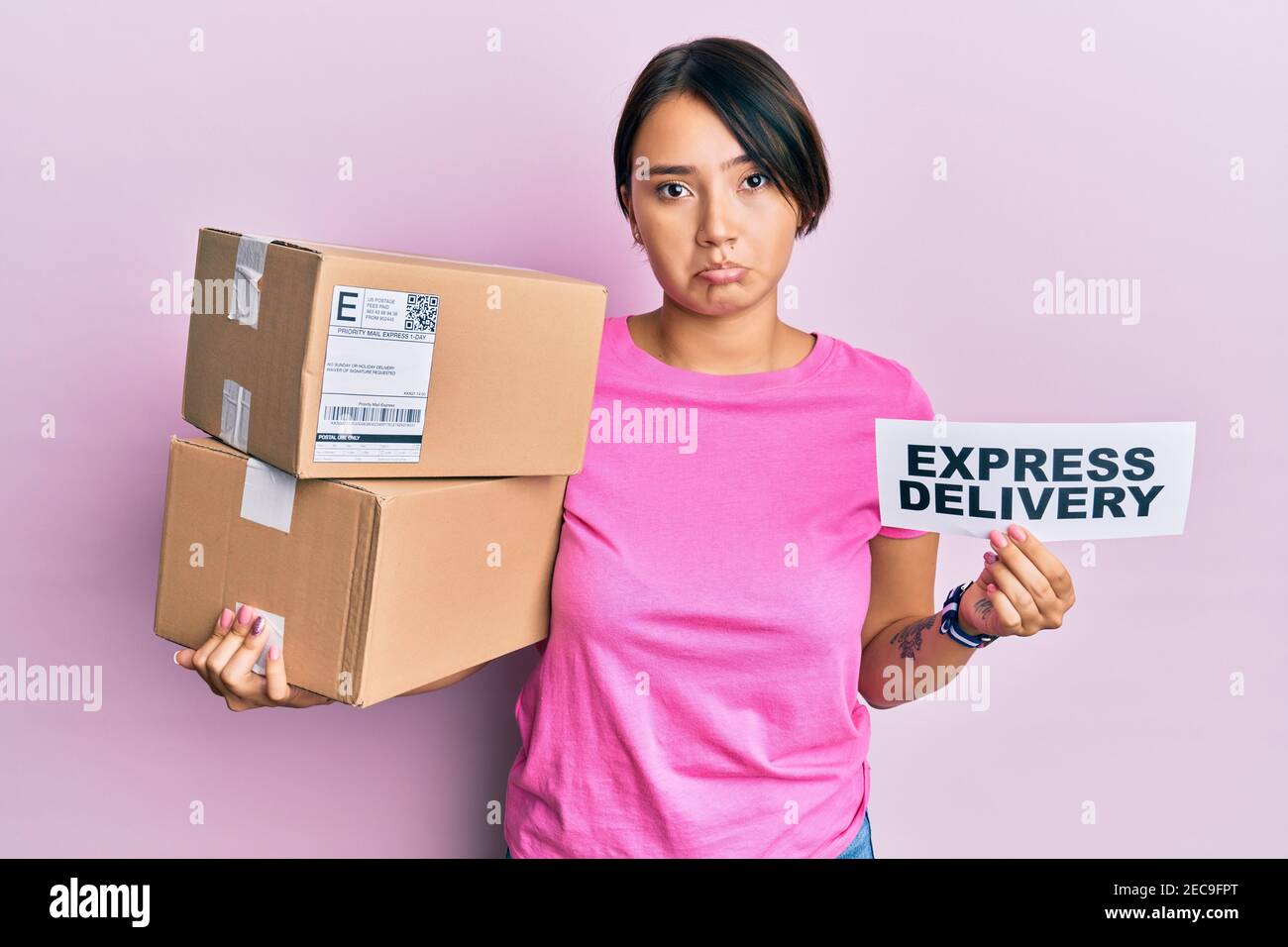 Beautiful young woman with short hair holding delivery box with express ...