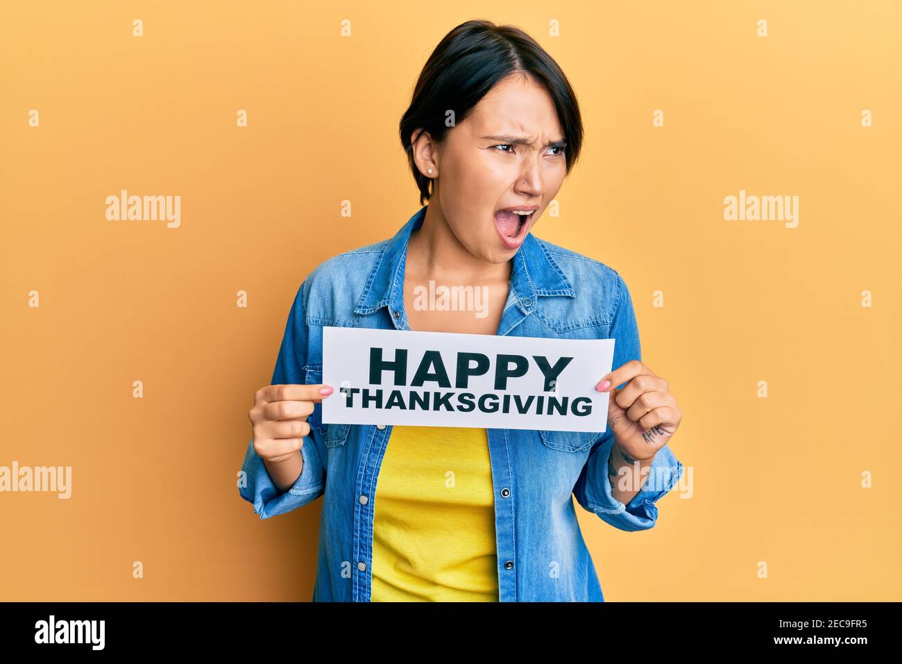 Beautiful young woman with short hair holding happy thanksgiving ...