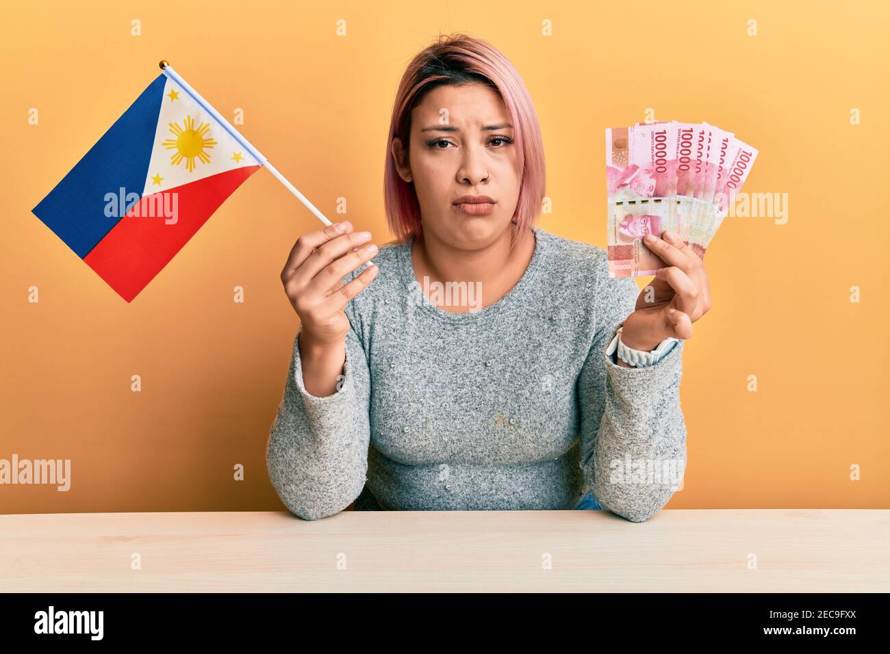 Hispanic woman with pink hair holding philippine flag and philippines ...