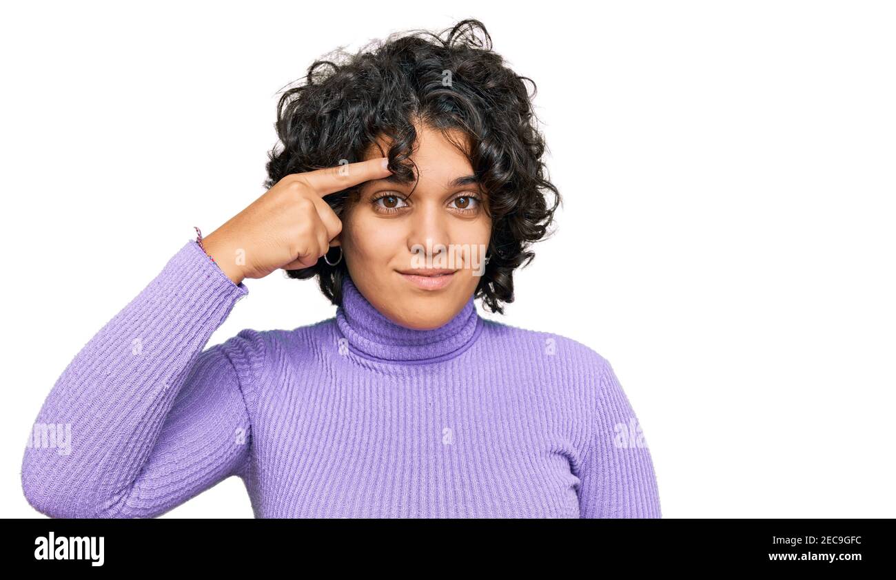 Young hispanic woman with curly hair wearing casual clothes pointing ...