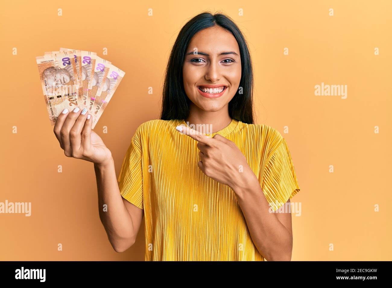 Young brunette woman holding south african 20 rand banknotes smiling ...