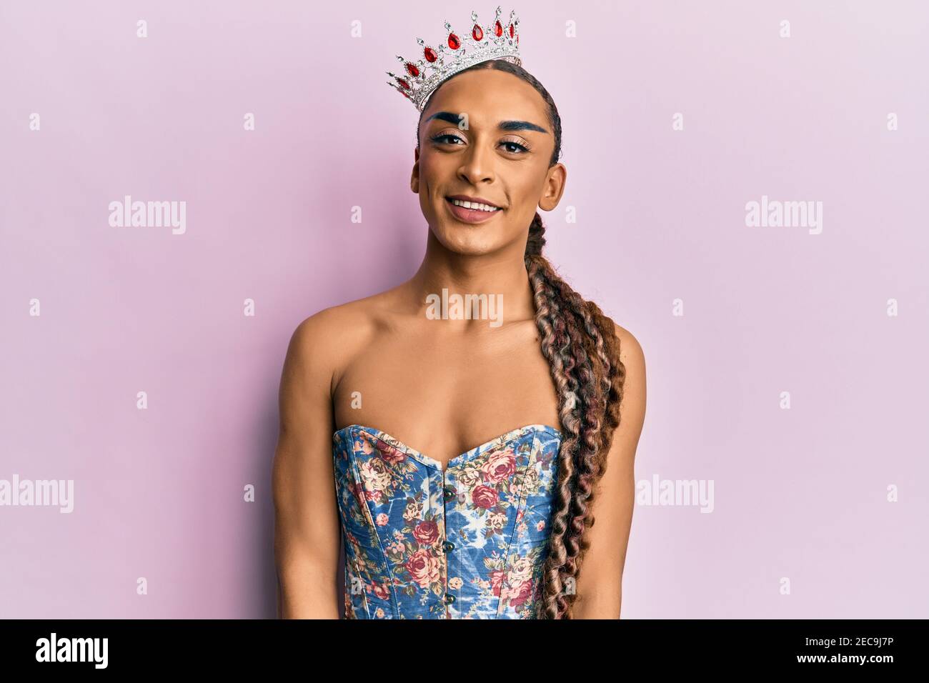 Hispanic man wearing make up and long hair wearing princess crown ...