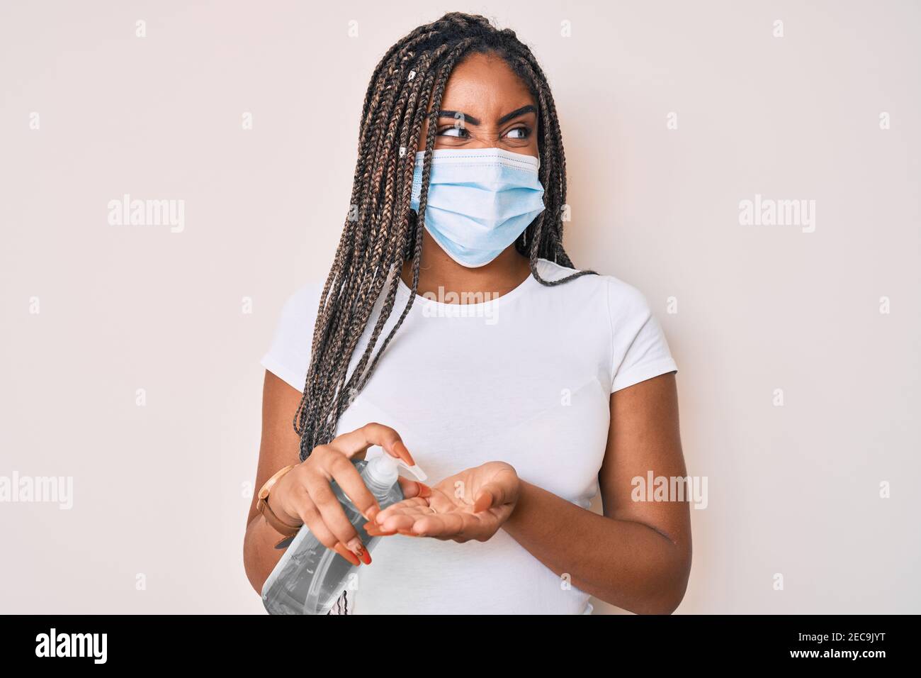 Young african american woman with braids wearing medical mask using ...