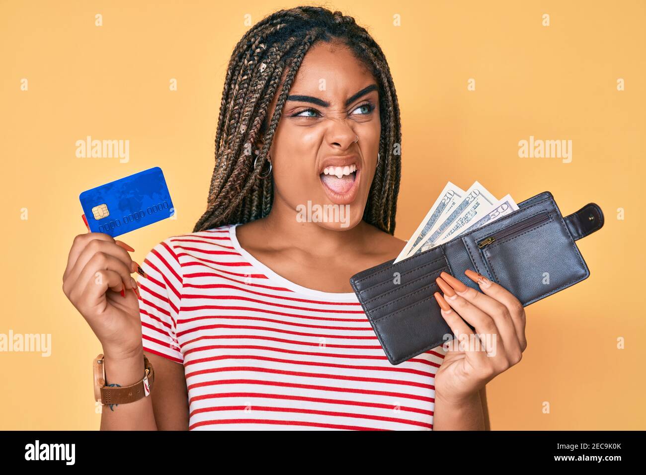 Young african american woman with braids holding wallet with dollars ...