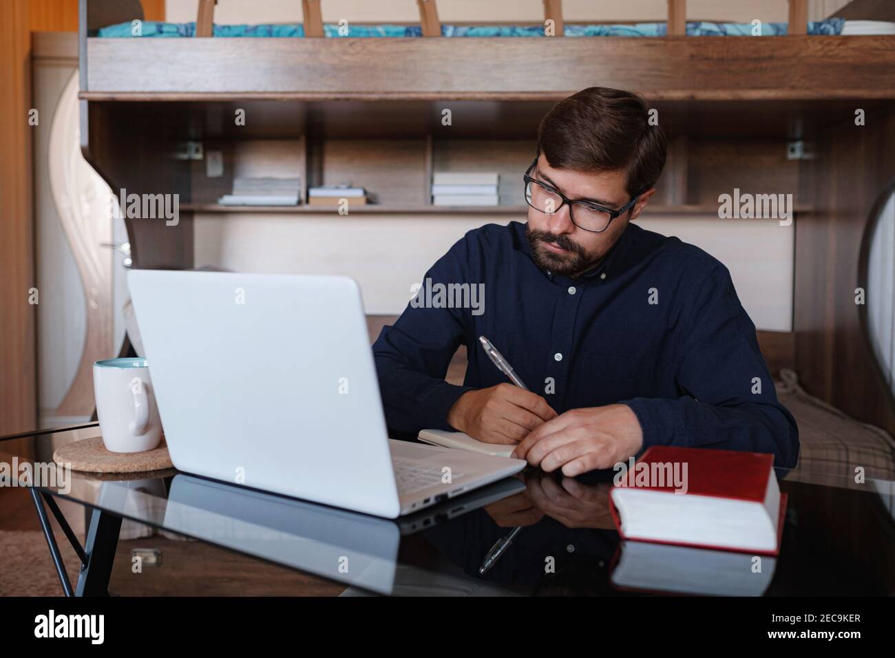 Focused serious male student using laptop looking at computer screen ...