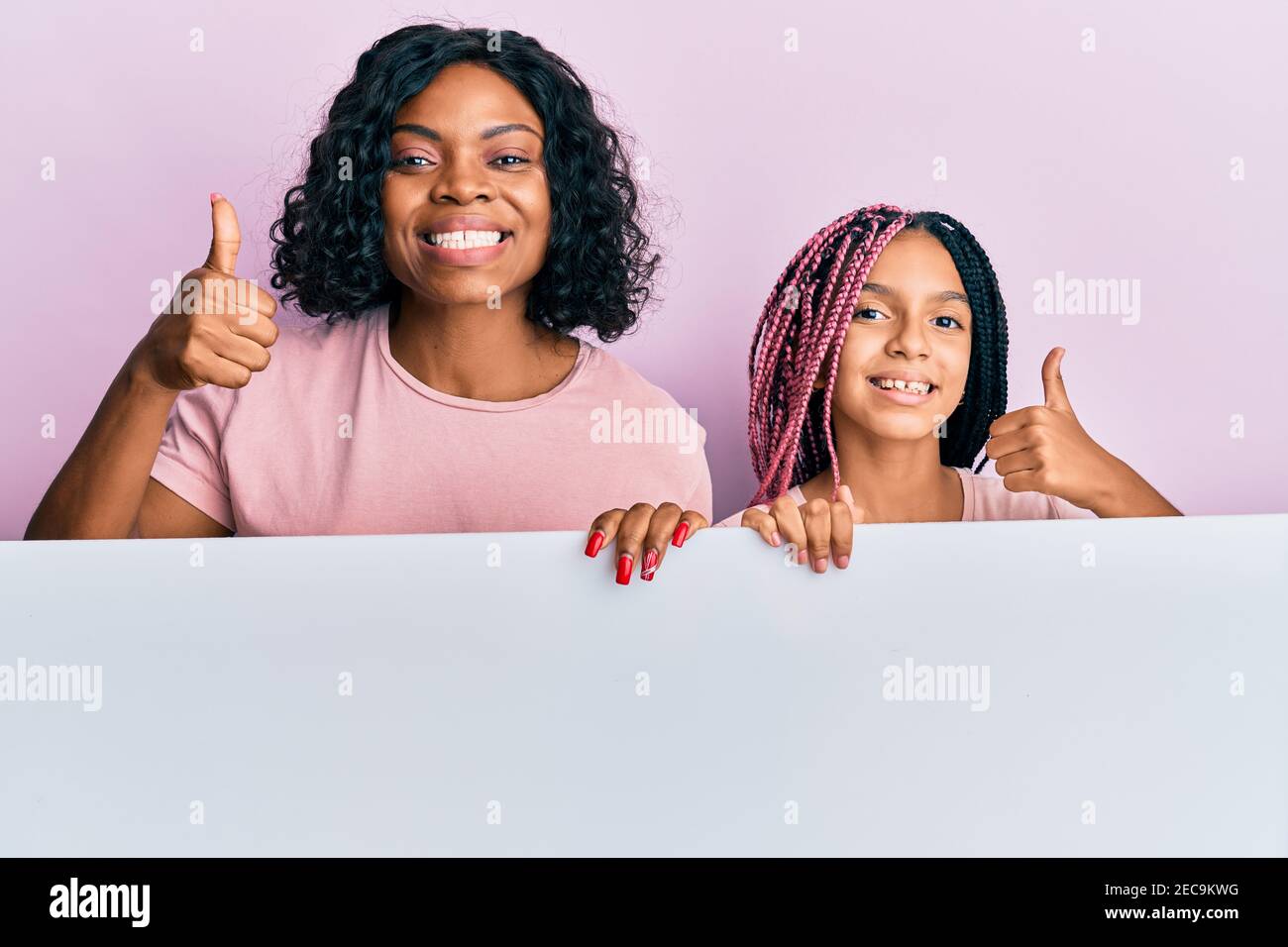 Beautiful african american mother and daughter holding blank empty ...