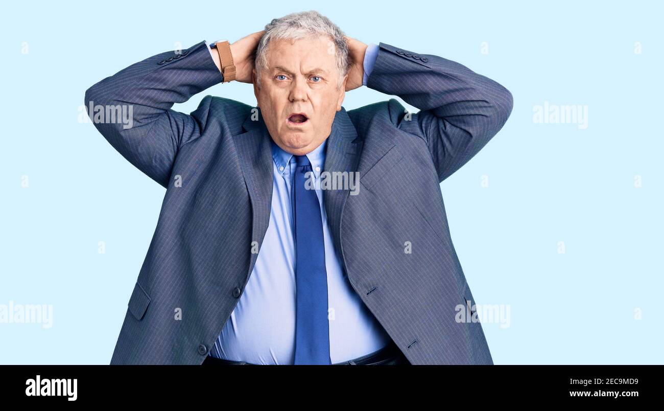 Senior grey-haired man wearing business jacket crazy and scared with ...