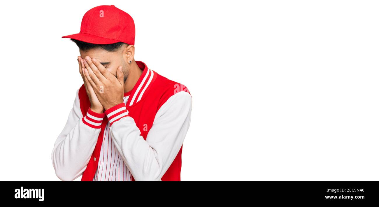 Young man with beard wearing baseball uniform with sad expression ...