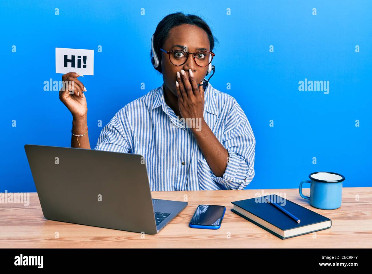 Young african woman wearing operator headset holding hi word covering ...