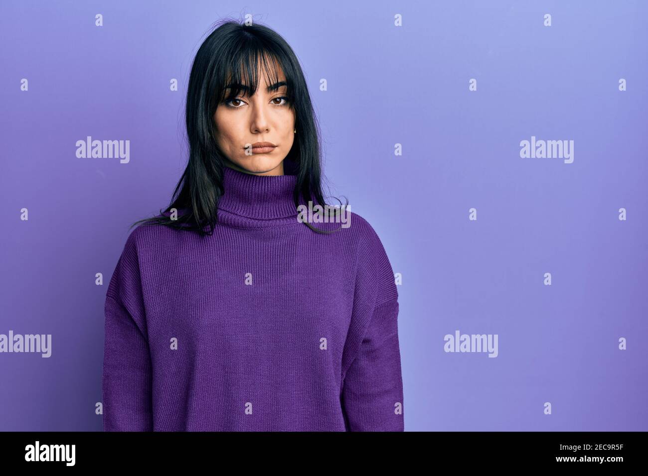 Young brunette woman with bangs wearing turtleneck sweater depressed ...