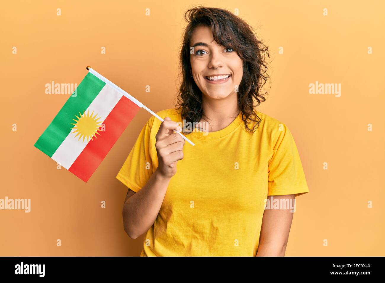 Young hispanic woman holding san fernando flag looking positive and ...
