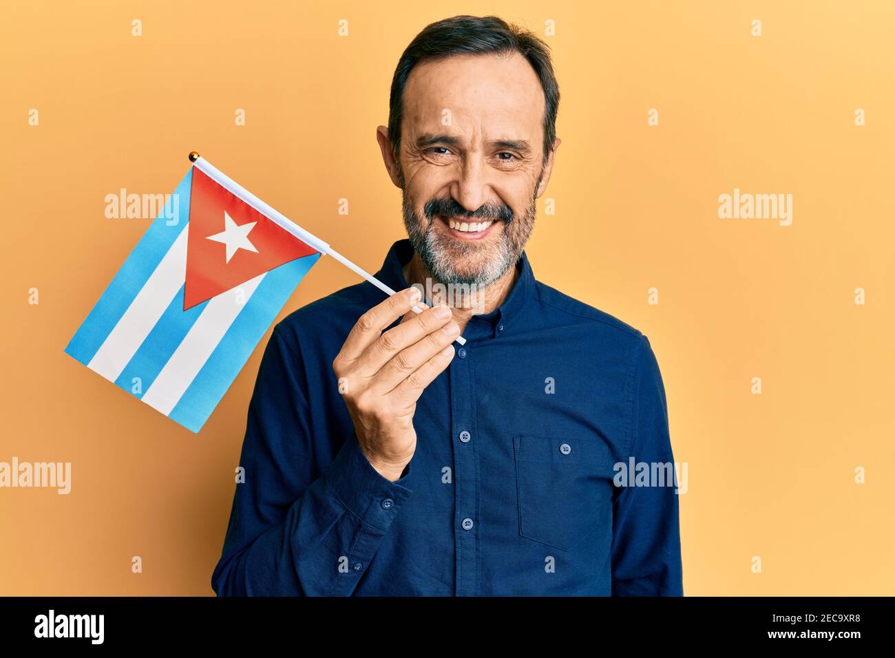 Middle age hispanic man holding cuba flag looking positive and happy ...