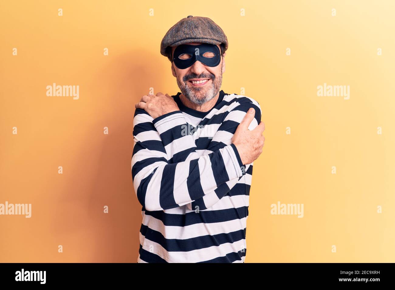 Middle age handsome burglar man wearing cap and mask over isolated ...