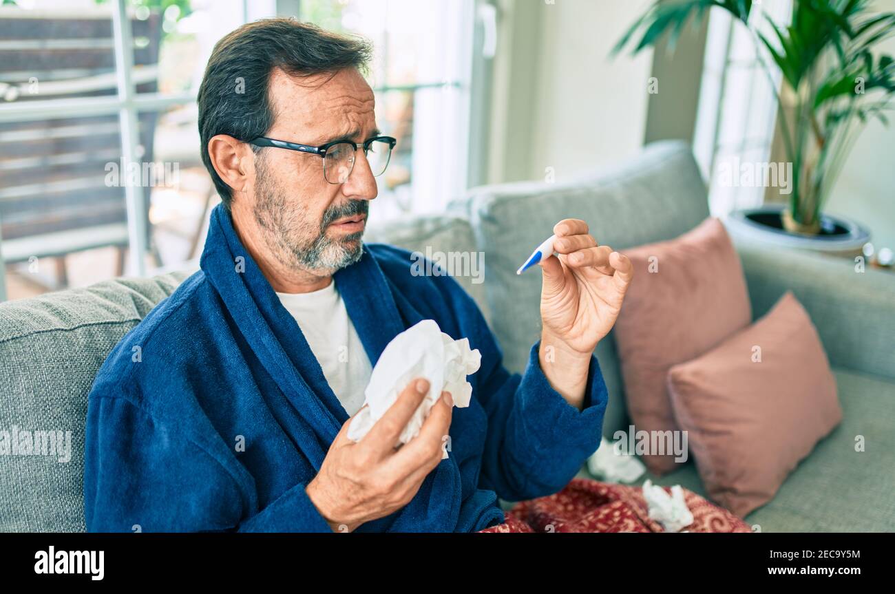 Middle age man feeling sick with cold and fever at home, ill with flu ...