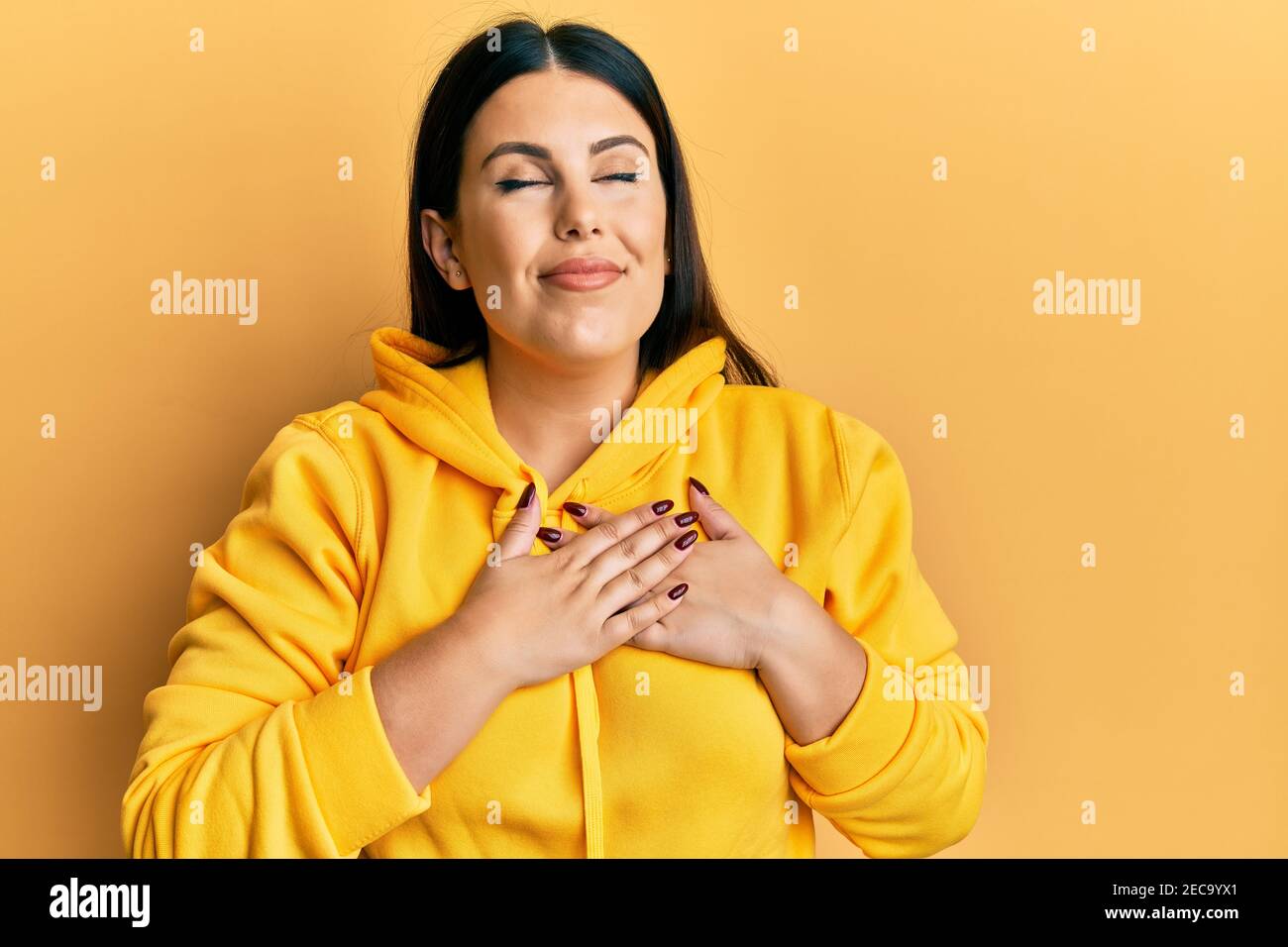 Beautiful Brunette Woman Wearing Casual Sweatshirt Smiling With Hands On Chest Eyes Closed With