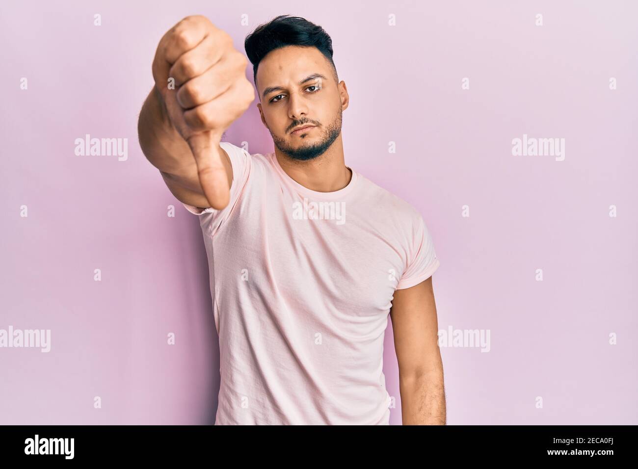Young arab man wearing casual clothes looking unhappy and angry showing ...