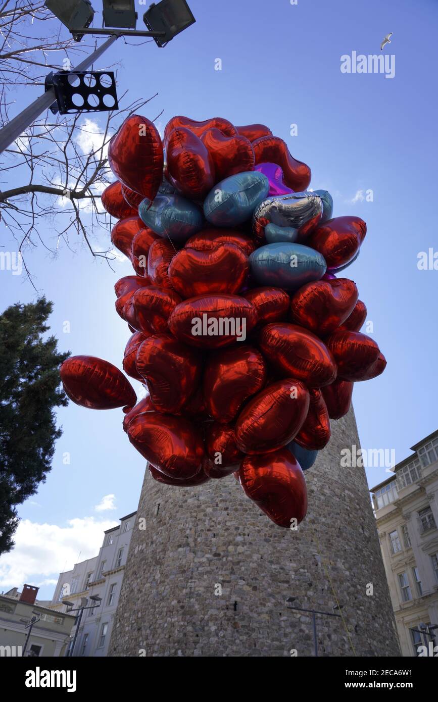 Vertical shot of heart-shaped balloons in front of the Galata tower ...