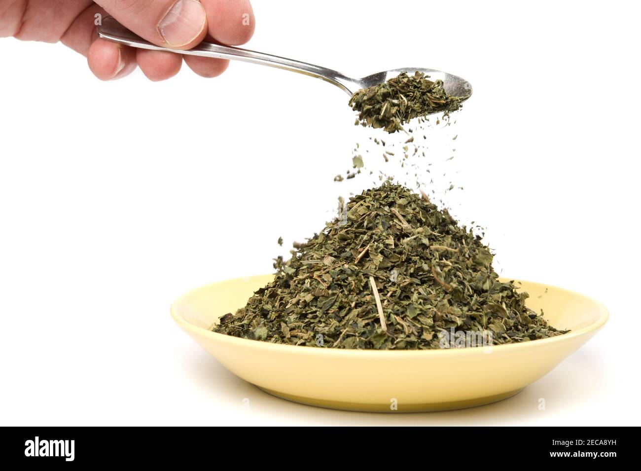 Heap and spoonful of dried herb on white Stock Photo - Alamy
