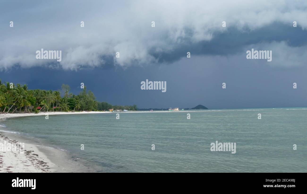 Waving blue sea, sandy shore of Samui Island during wet rain season ...