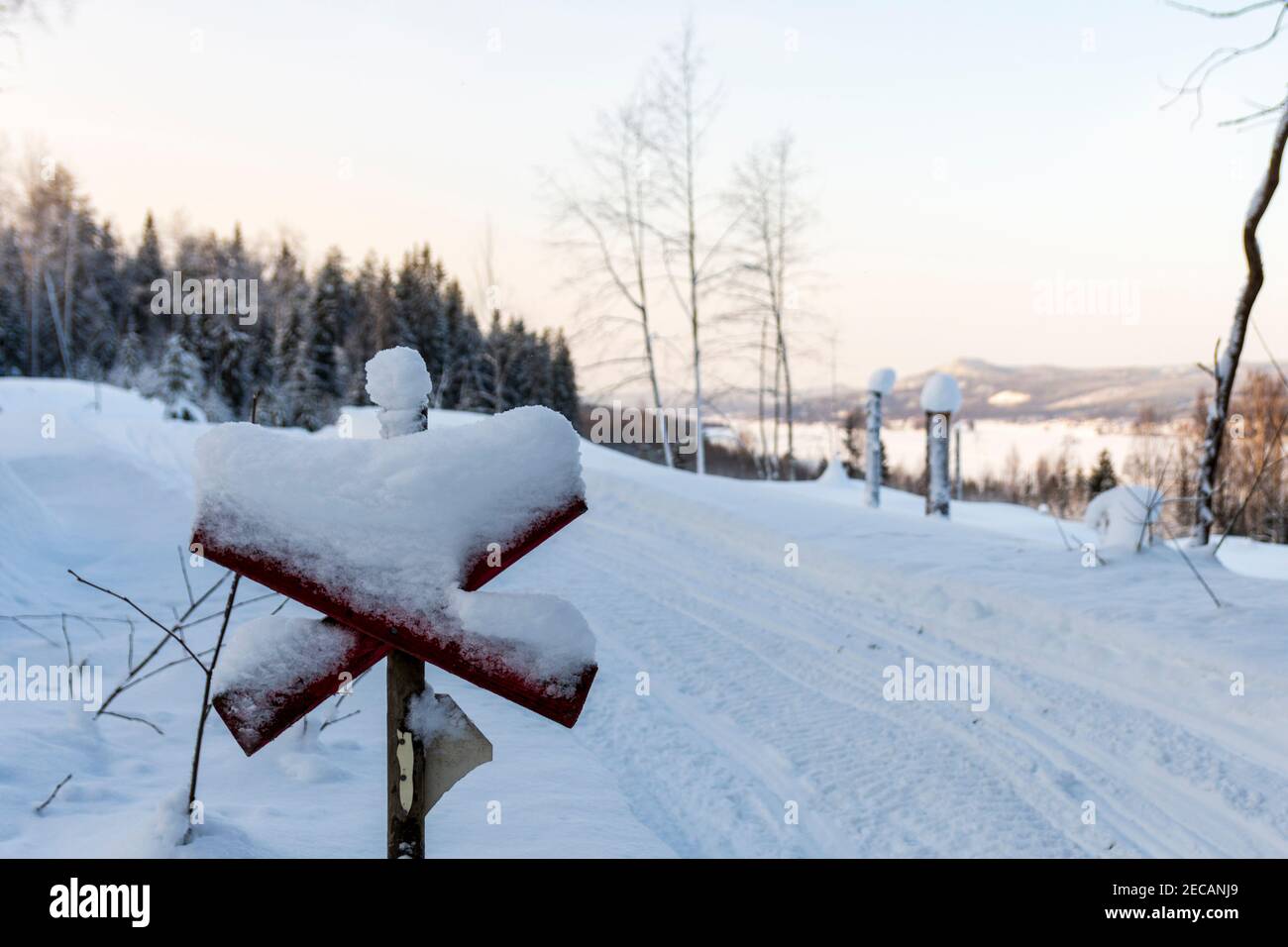 Sign marking a snowmobile trail in foreground and out of focus in ...