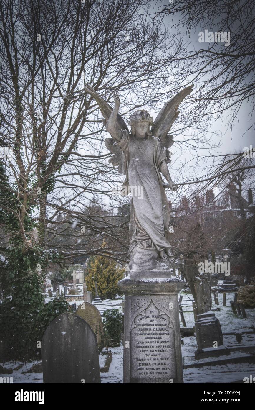 A gravestone with an angel statue in Hampstead Cemetery, snow ...