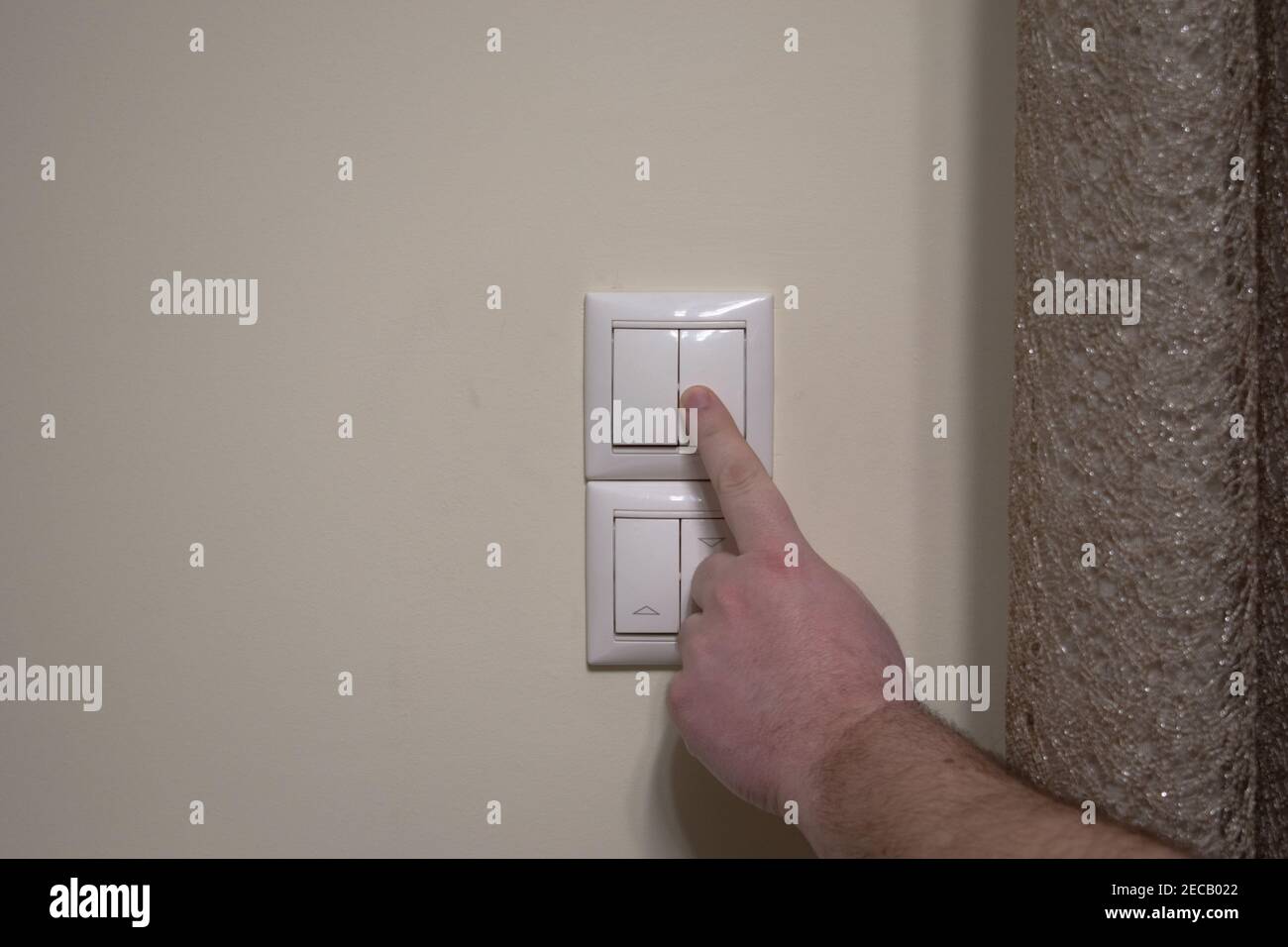 Finger pressing light switch to turn off the light. Modern white light ...