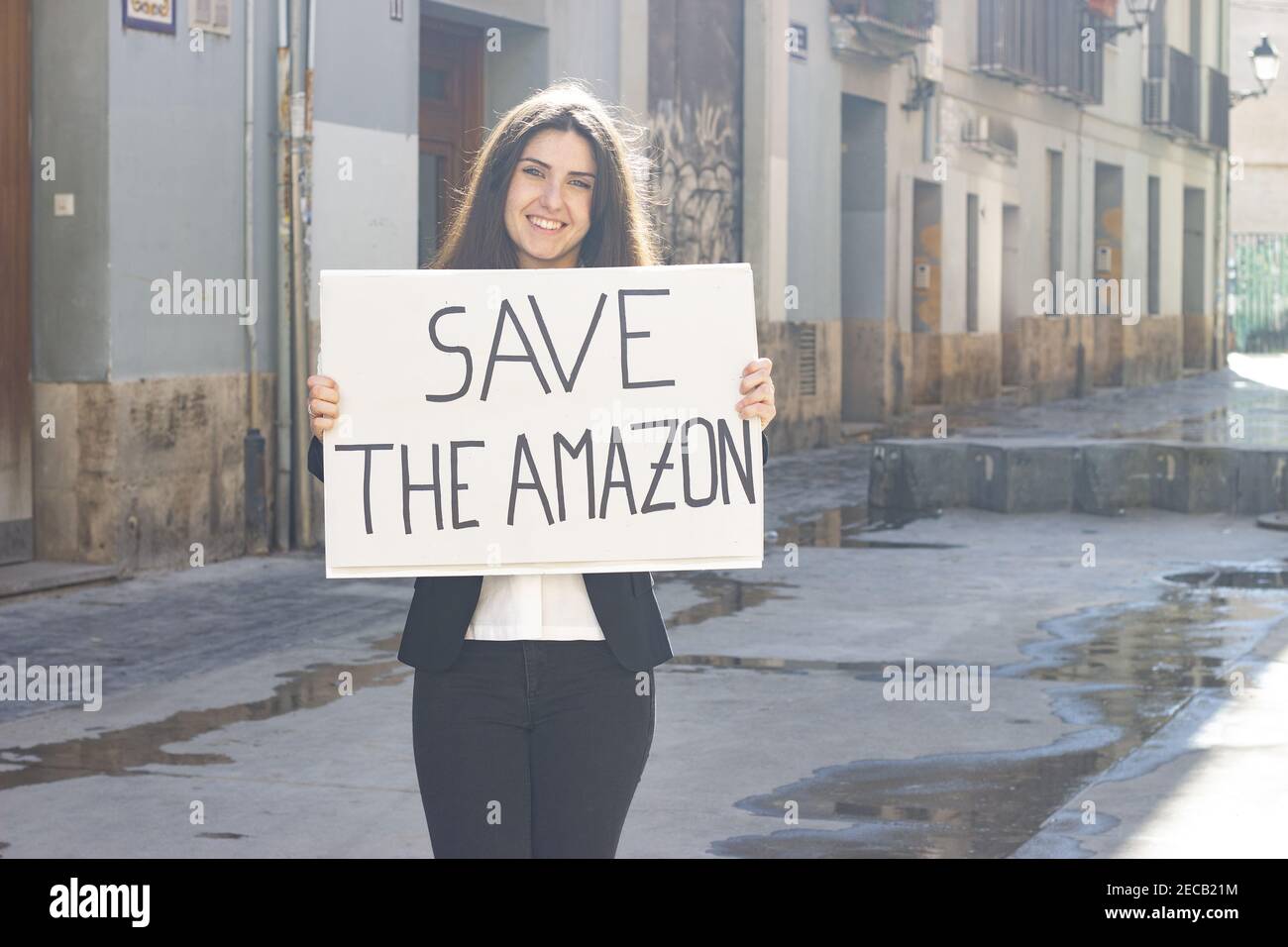 Shallow focus of a female environmental activist holding a "SAVE AMAZON ...