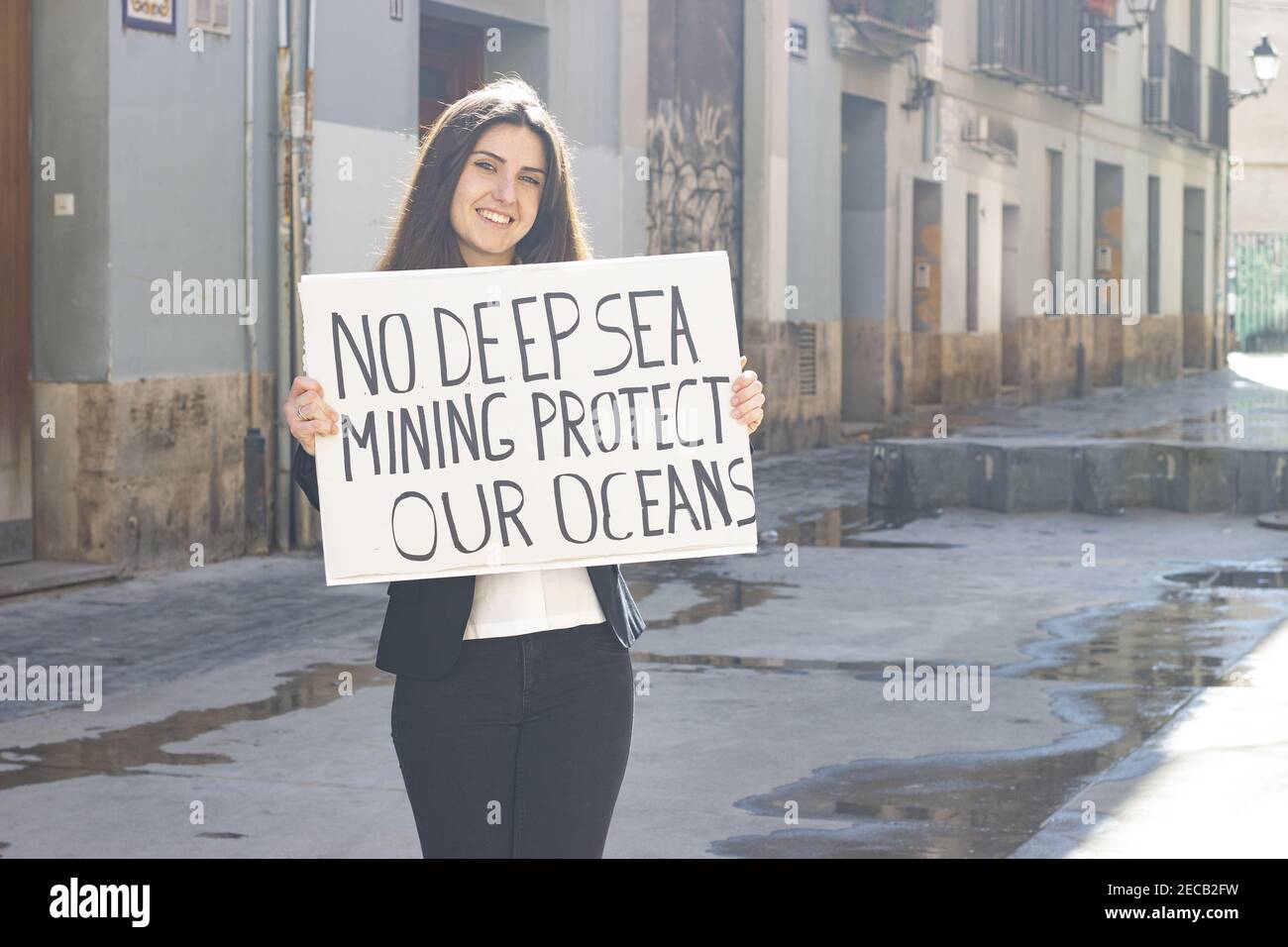 Female environmental activist holding a poster with a "NO DEEP SEA ...