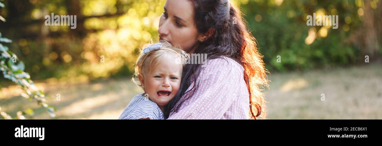Mother hugging pacifying sad upset crying toddler girl. Family young ...