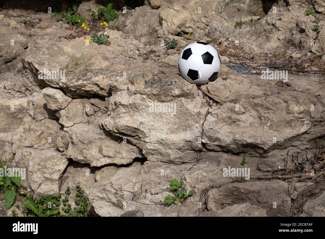 Football and the dark stone. Ball is situated on the rock Stock Photo ...