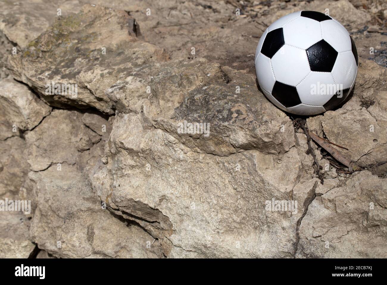 Football and the dark stone. Ball is situated on the rock Stock Photo ...