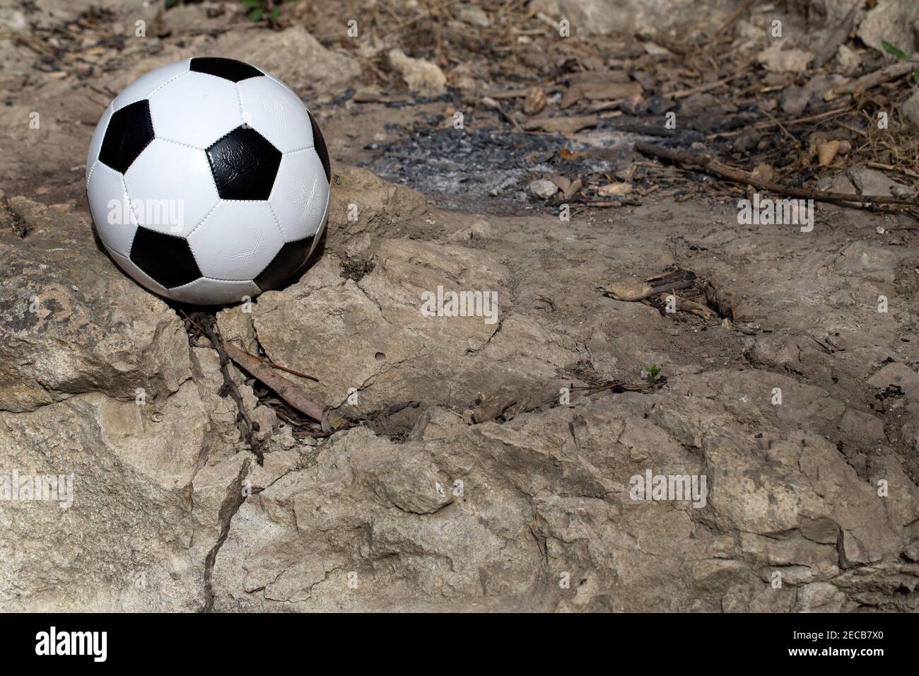 Football and the dark stone. Ball is situated on the rock Stock Photo ...