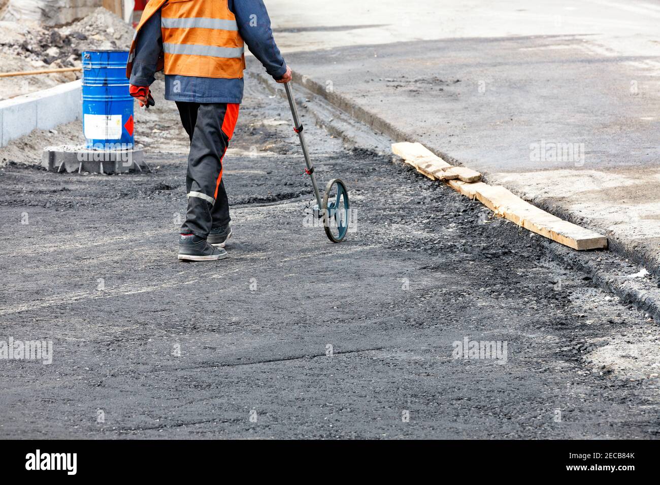A road service engineer measures the work area with an electronic ...