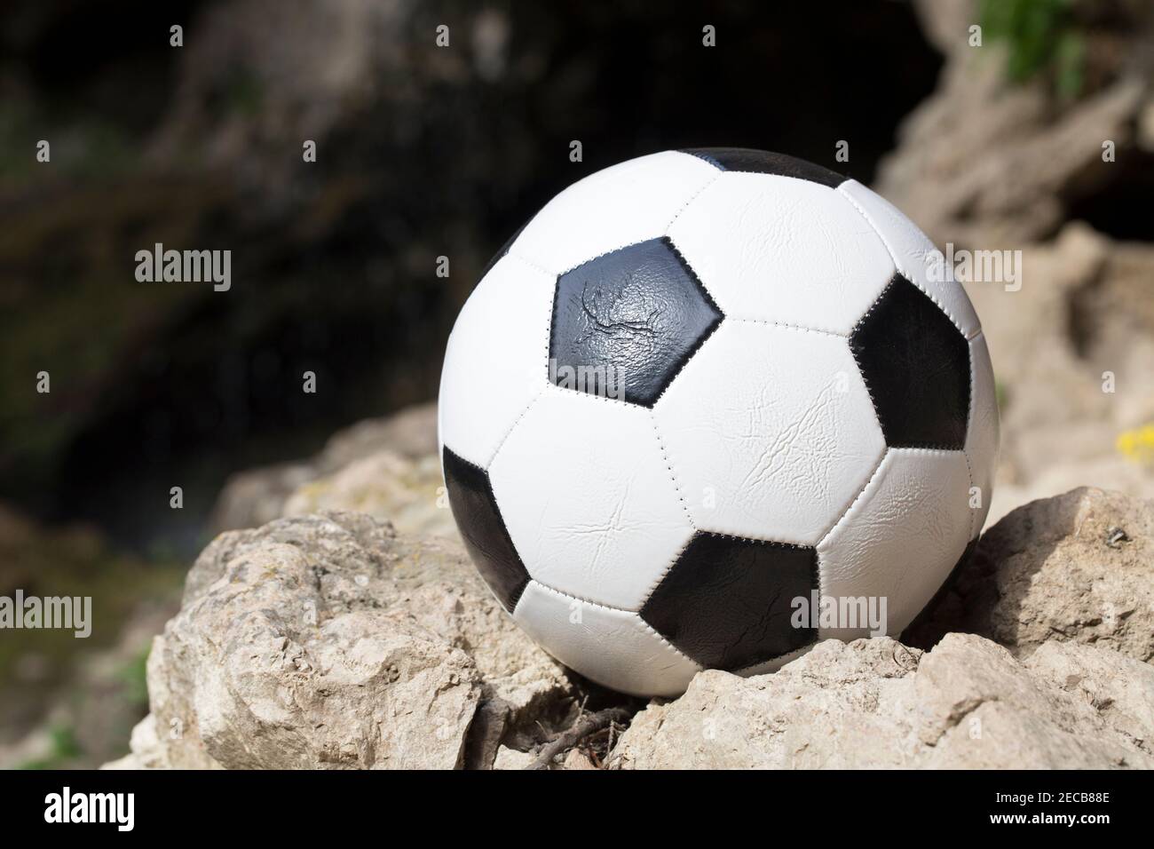 Football and the dark stone. Ball is situated on the rock Stock Photo ...