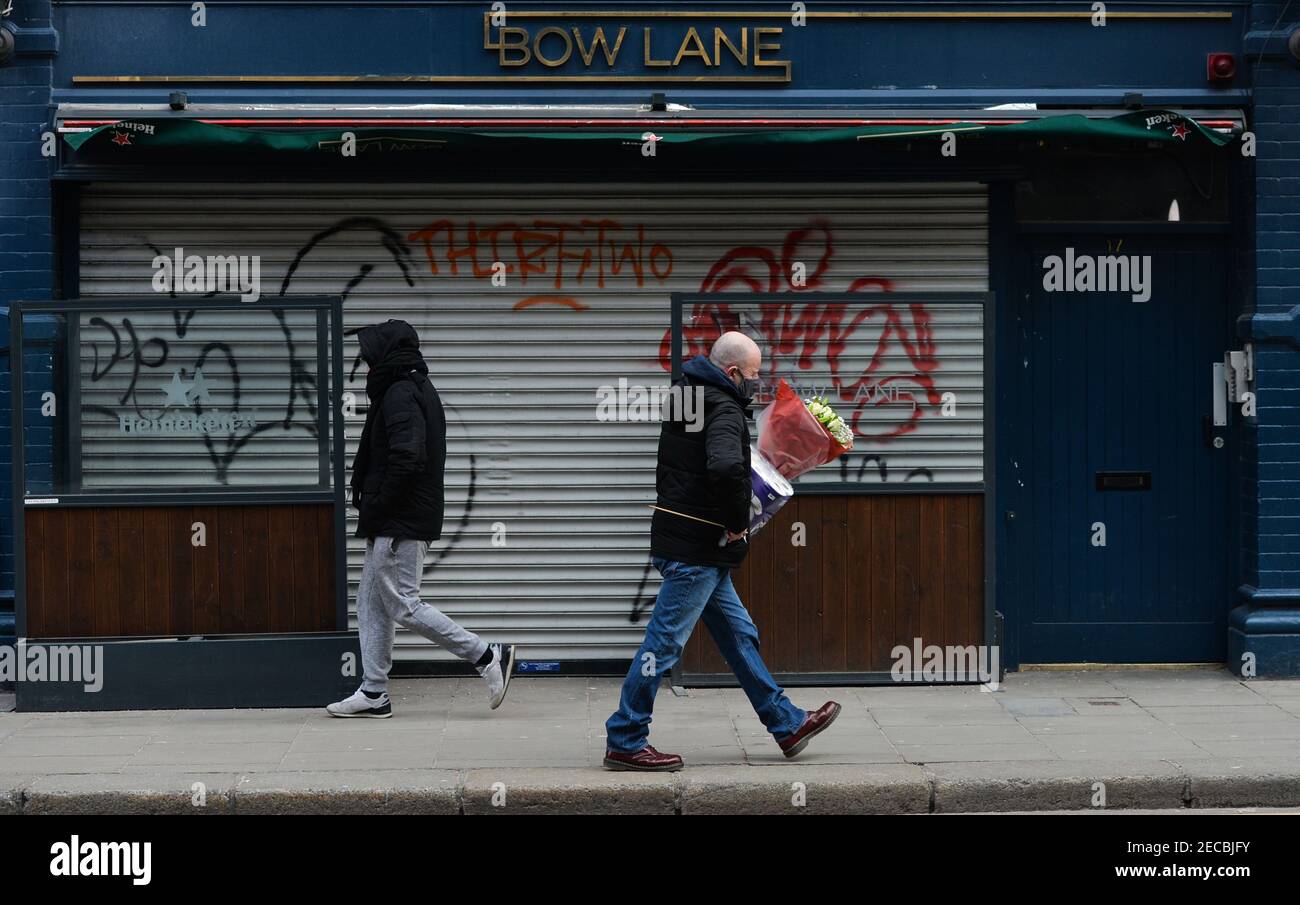 Dublin, Ireland. 12th Feb, 2021. People walking by a closed business ...