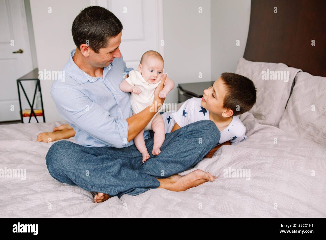 Fathers Day holiday. Caucasian father dad holding newborn baby. Brother ...