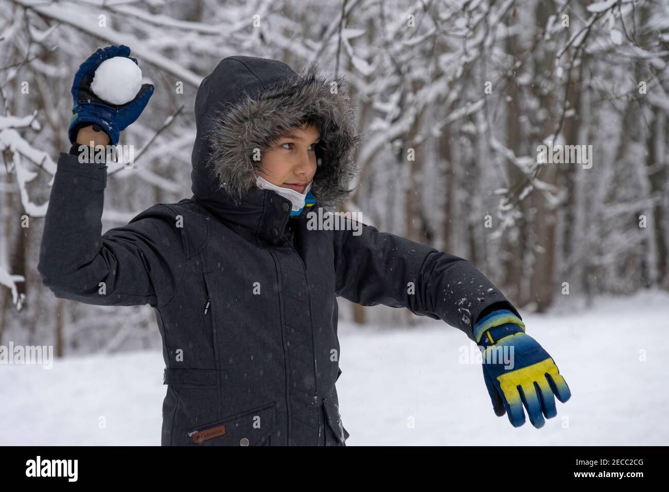Kid boy wearing medical protective mask playing snowball. Active winter ...