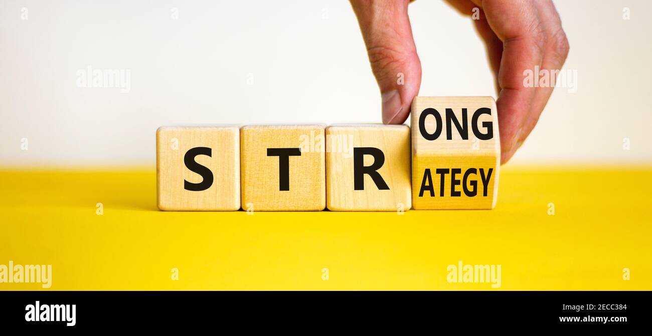 Strong strategy symbol. Businessman turns a wooden cube with words ...