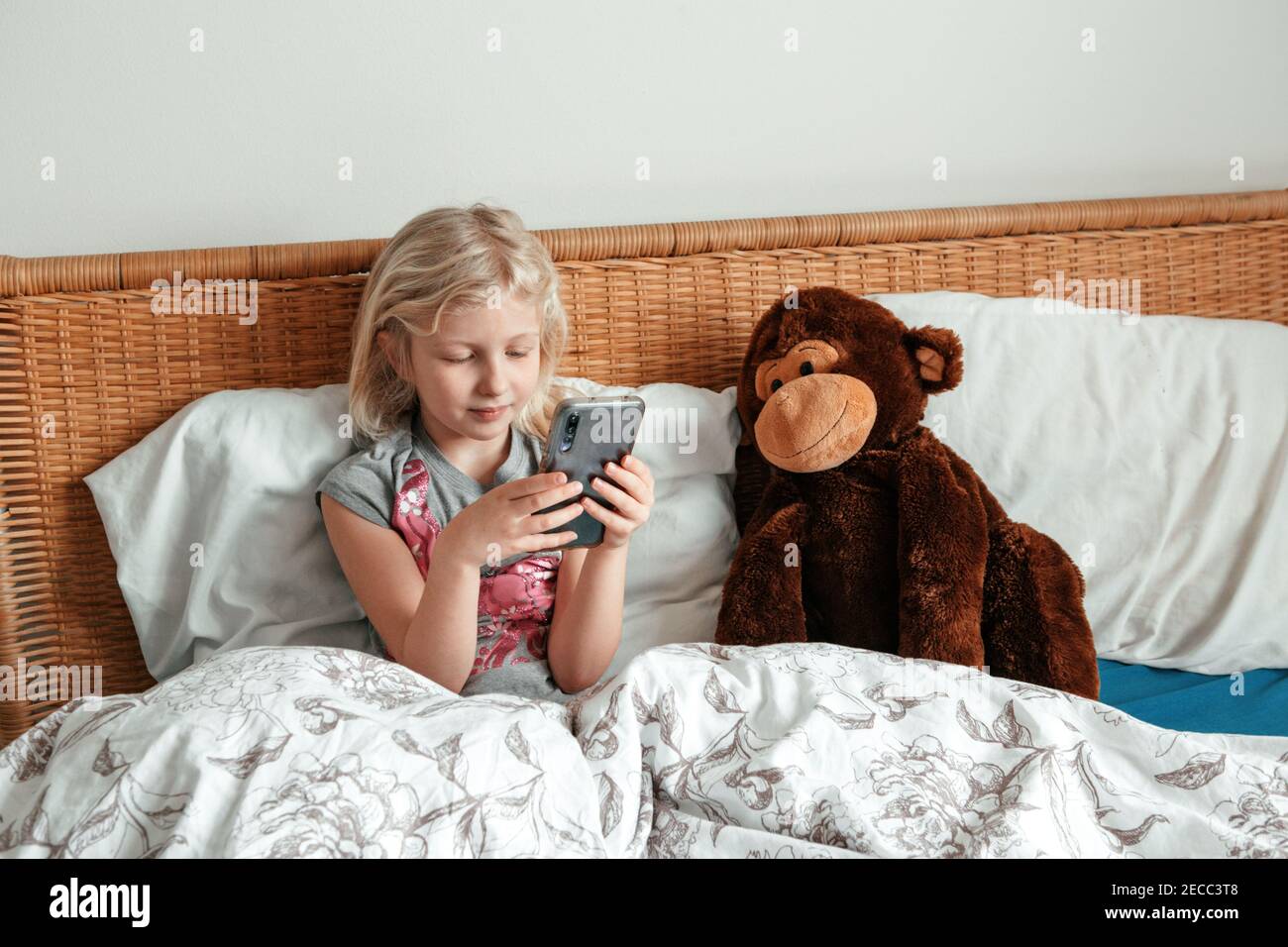 Cute girl sitting in bed in morning and texting talking at social media ...